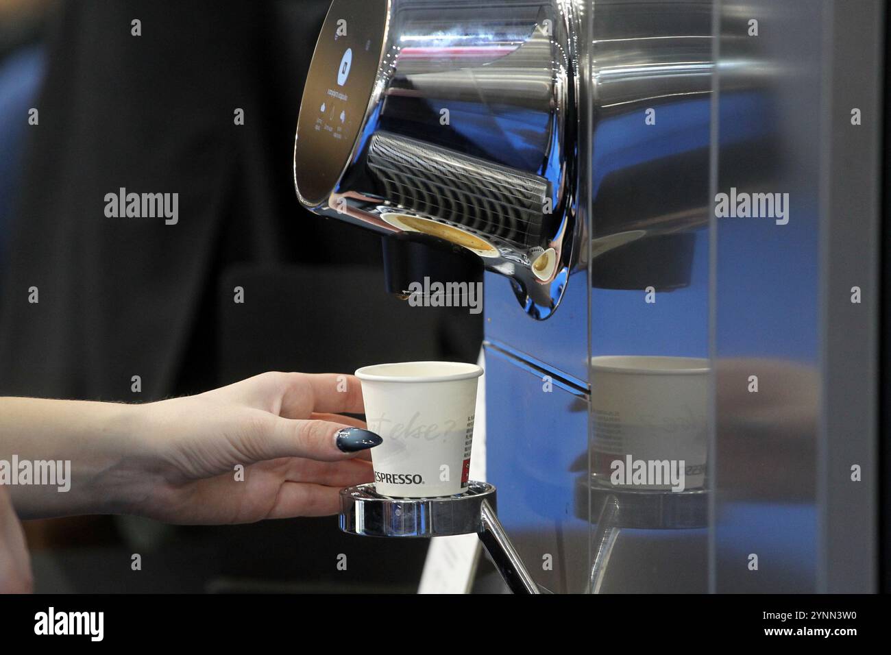 Fresh espresso dripping into a Nespresso-branded paper cup Stock Photo ...
