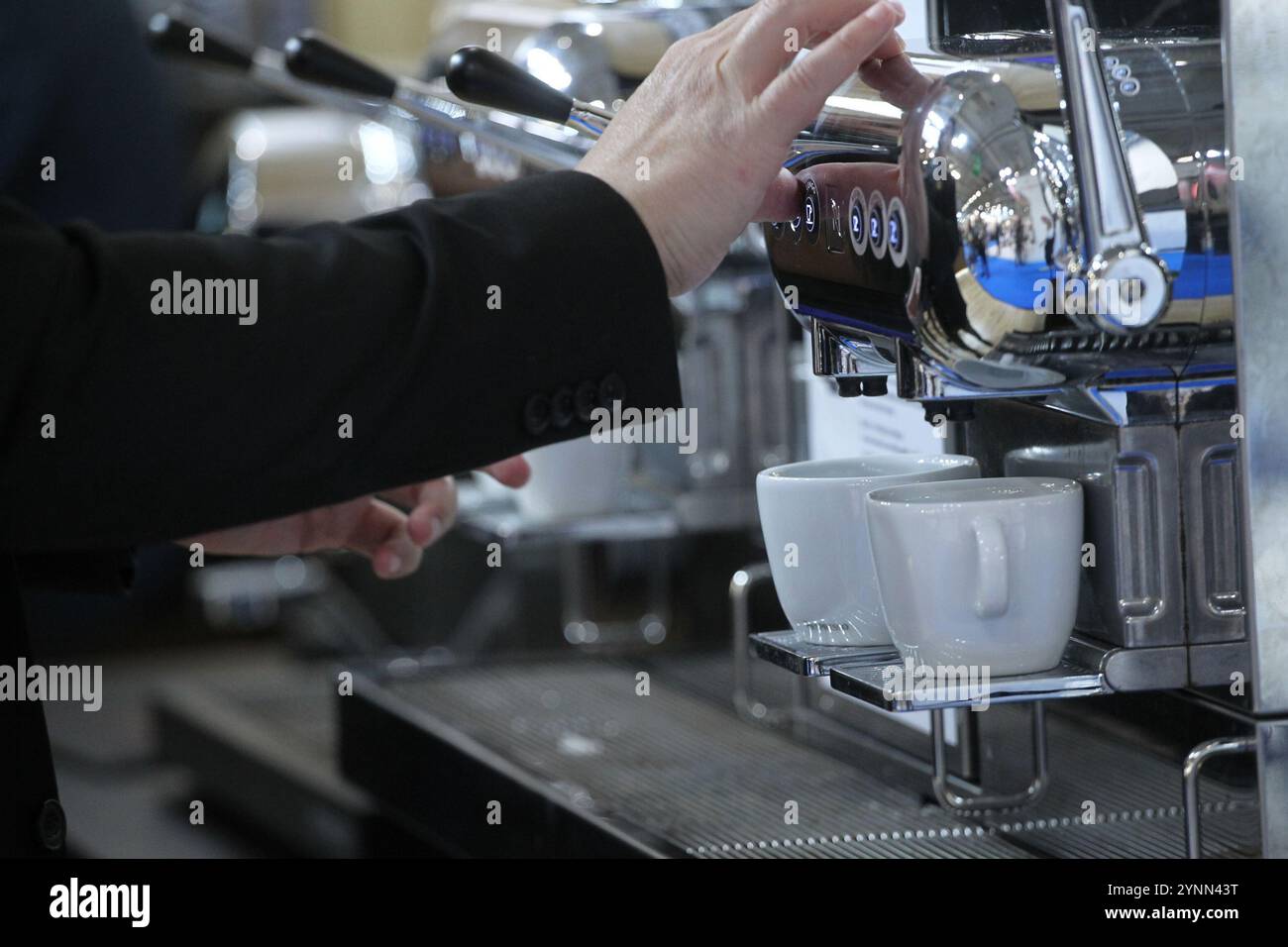 Fresh espresso dripping into a Nespresso-branded paper cup Stock Photo ...