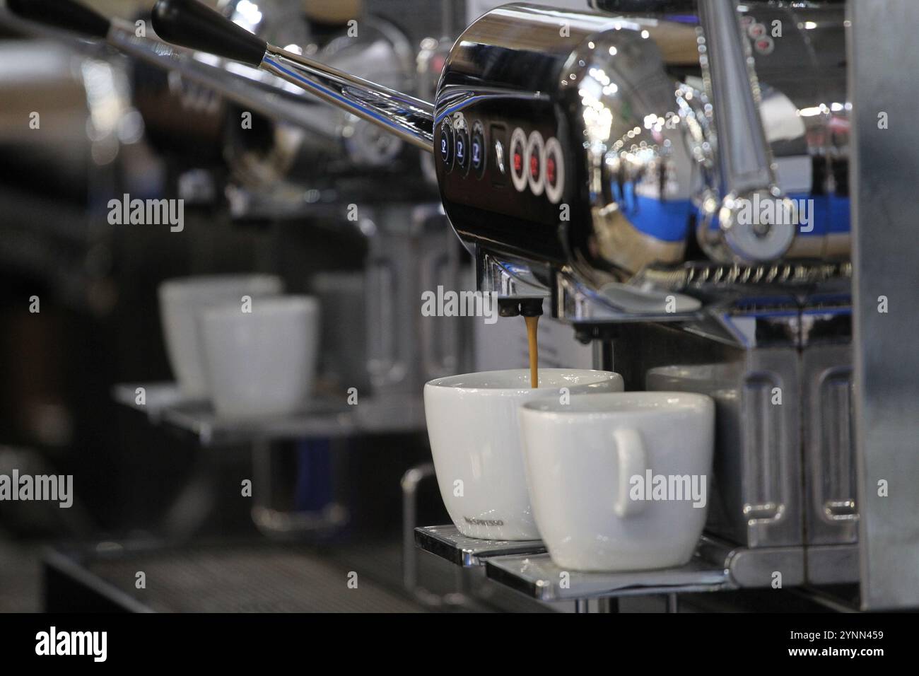 Fresh espresso dripping into a Nespresso-branded paper cup Stock Photo ...