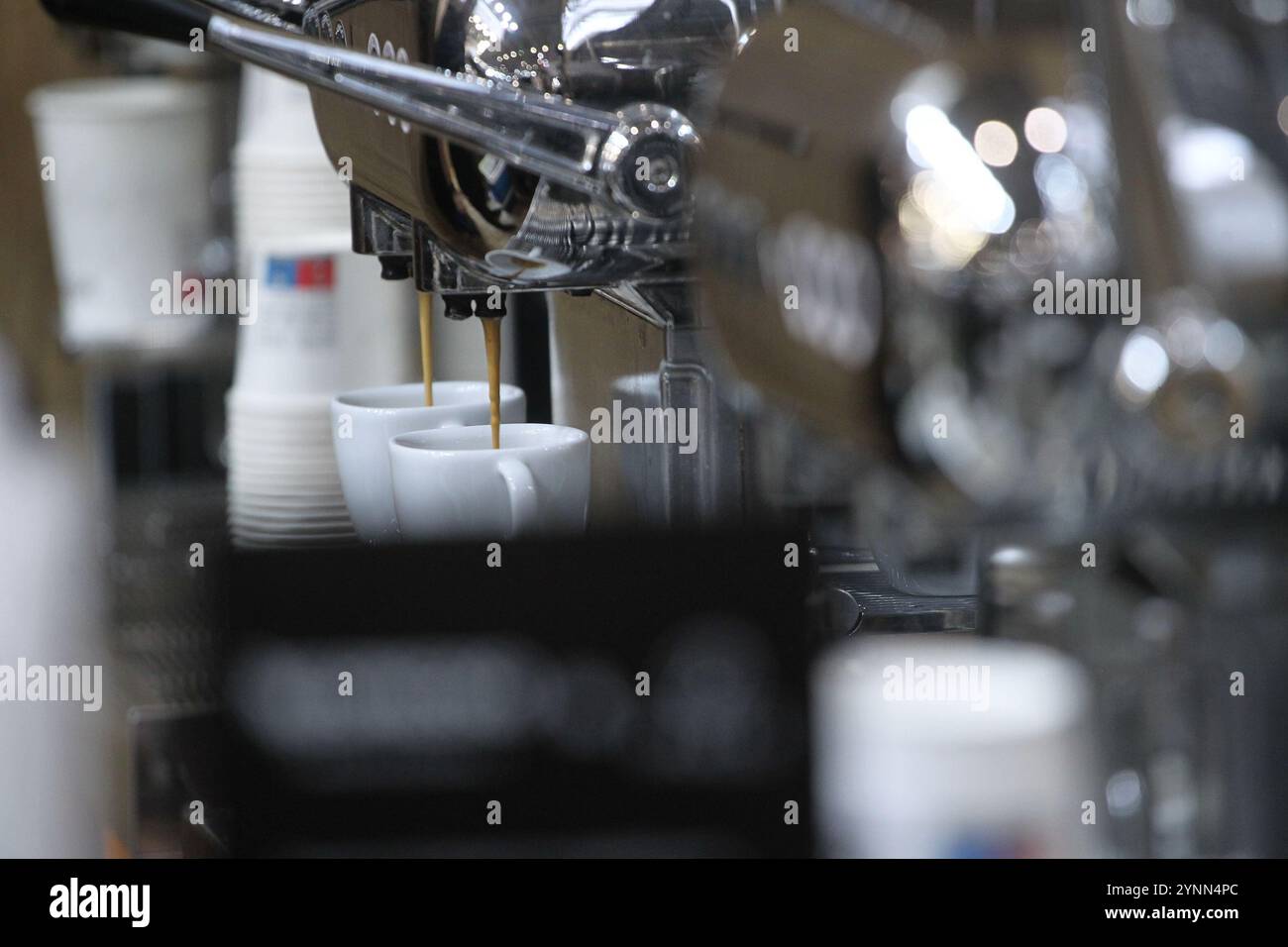 Fresh espresso dripping into a Nespresso-branded paper cup Stock Photo ...