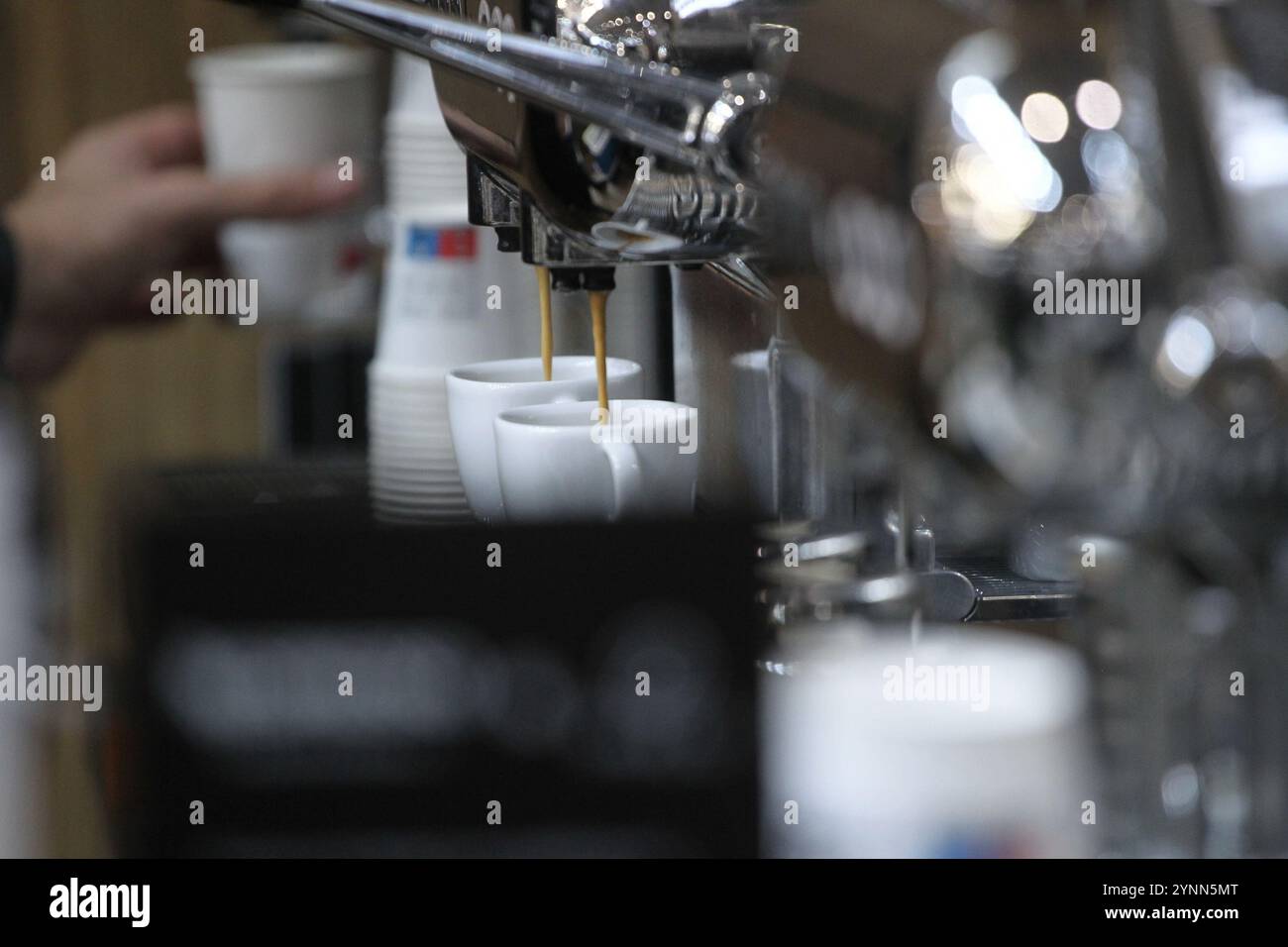 Fresh espresso dripping into a Nespresso-branded paper cup Stock Photo ...