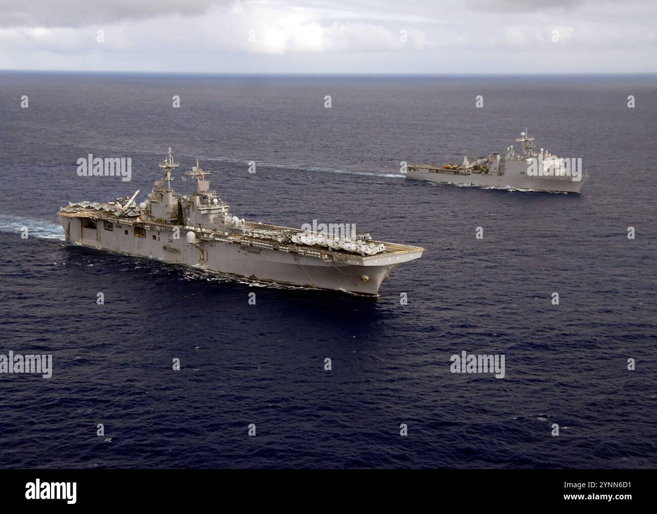 The amphibious assault ship USS Boxer, left, is underway with the ...