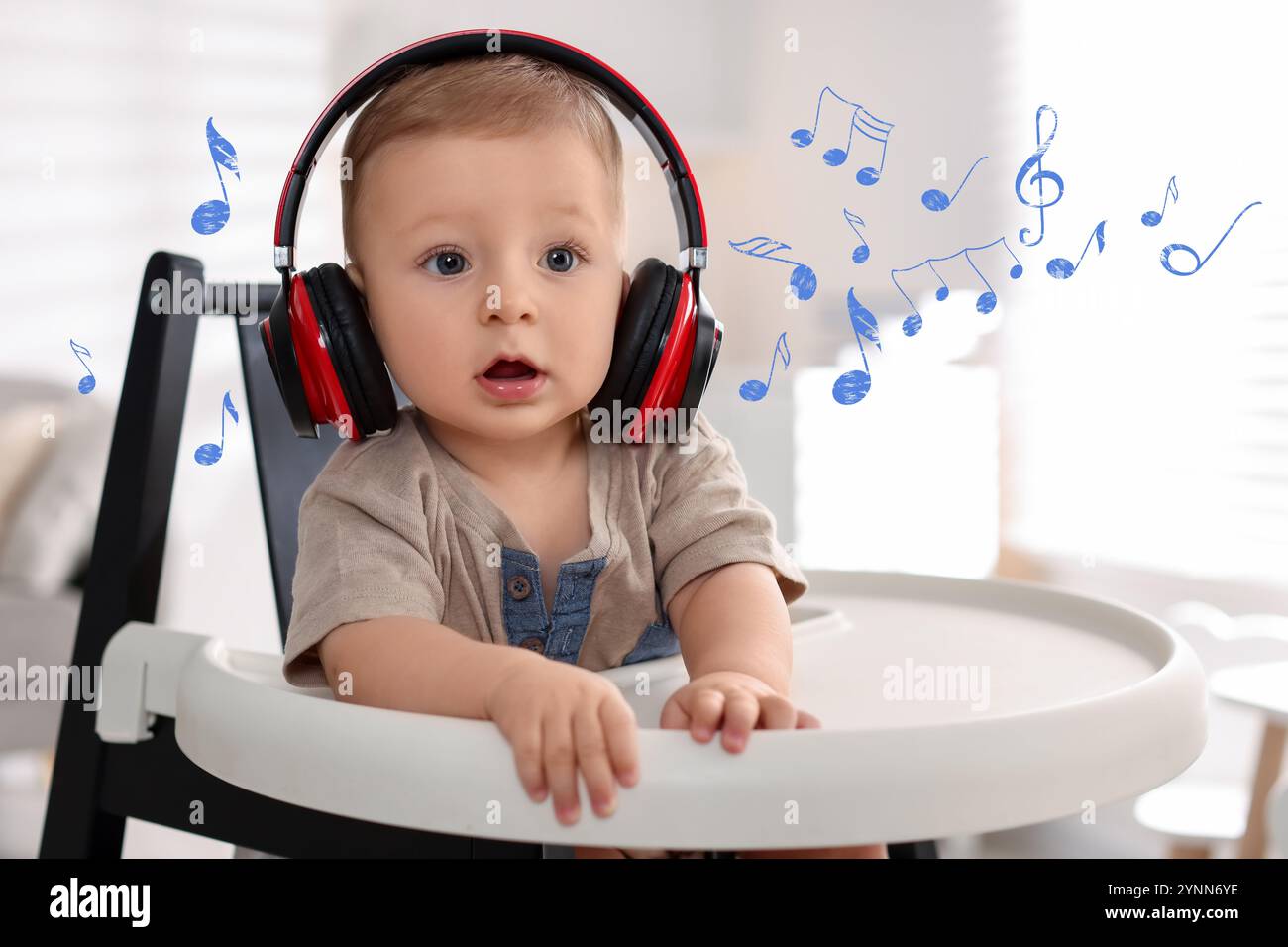 Cute little baby with headphones on high chair at home. Music notes ...