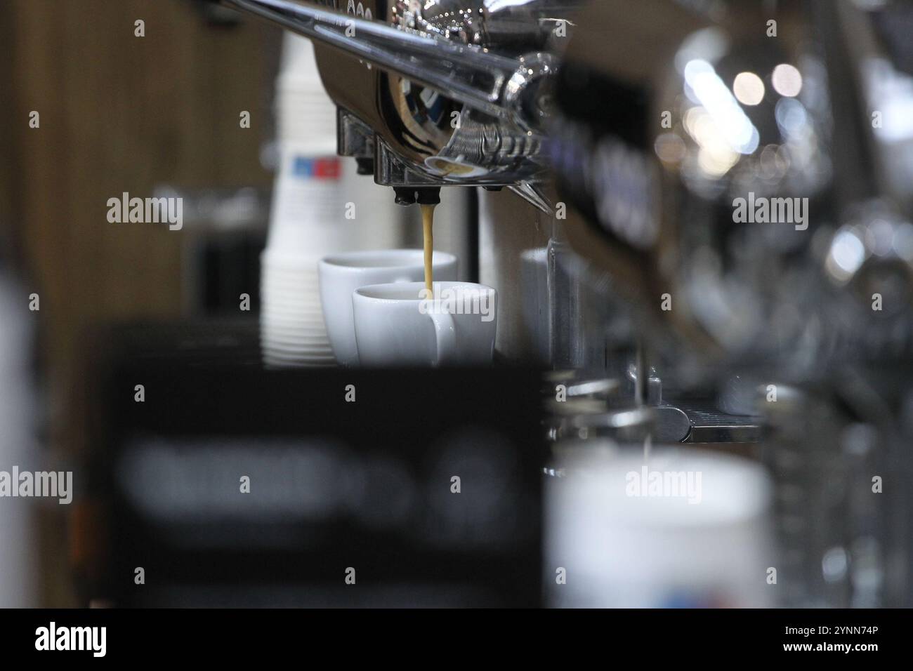 Fresh espresso dripping into a Nespresso-branded paper cup Stock Photo ...