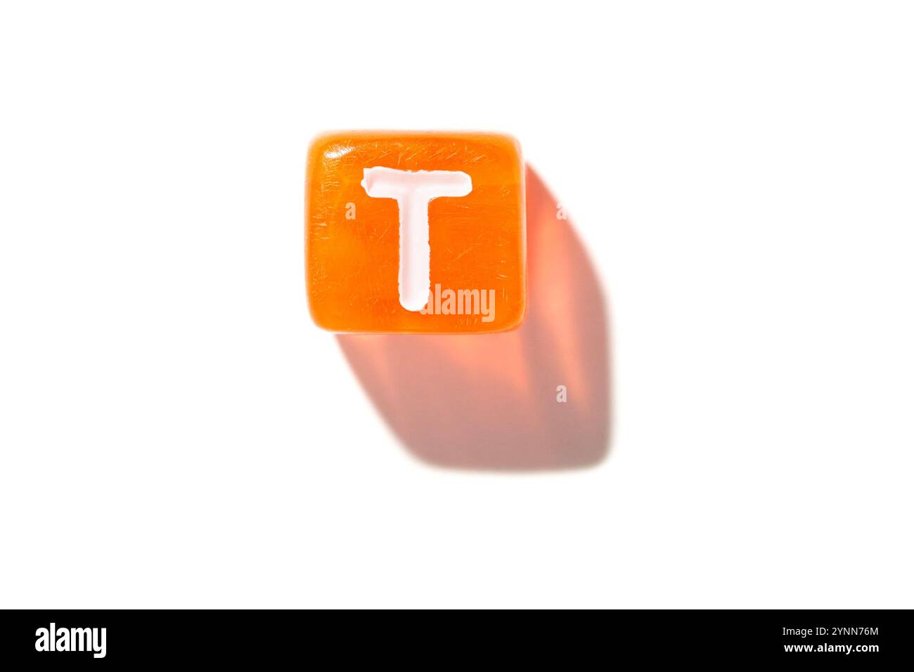Orange soap cube with letter t casting shadow on white background Stock ...