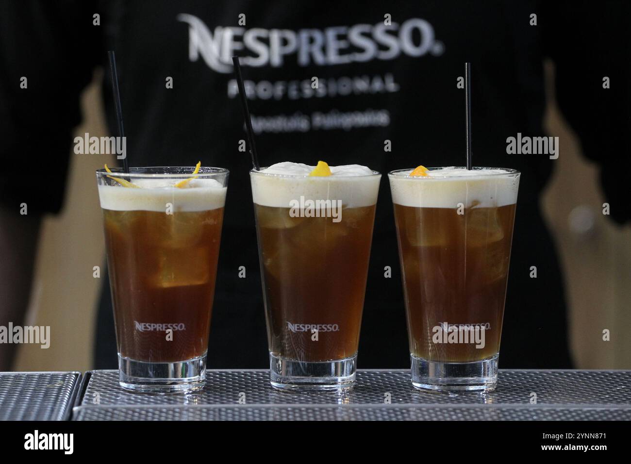 Fresh espresso dripping into a Nespresso-branded paper cup Stock Photo ...