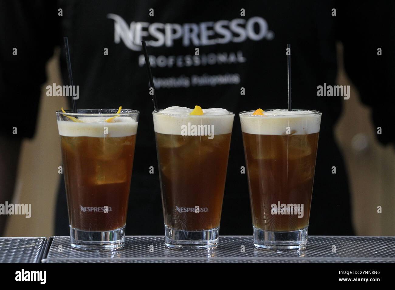 Fresh espresso dripping into a Nespresso-branded paper cup Stock Photo ...