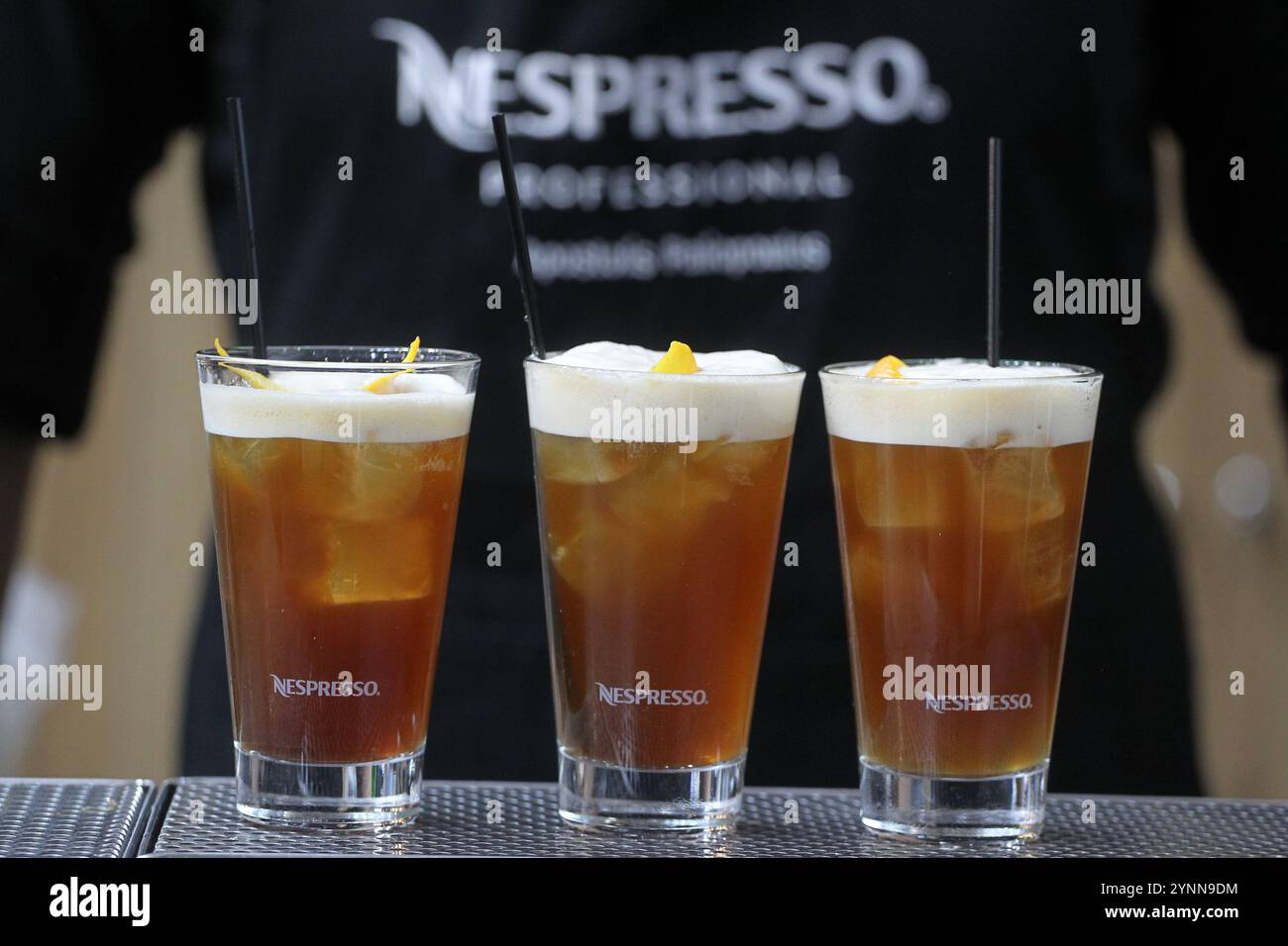 Fresh espresso dripping into a Nespresso-branded paper cup Stock Photo ...