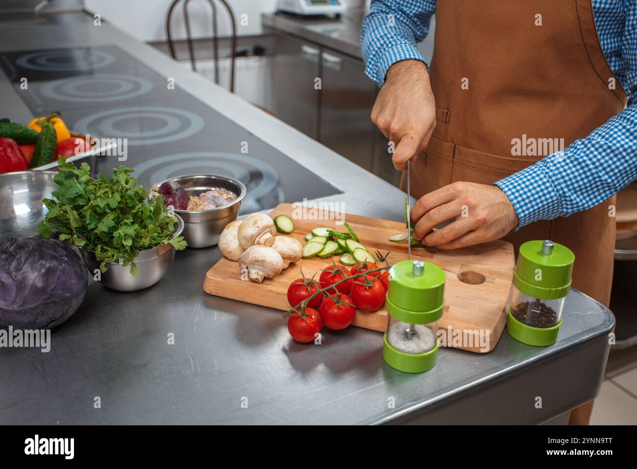 The chef in brown apron cooking in a restaurant kitchen Stock Photo - Alamy