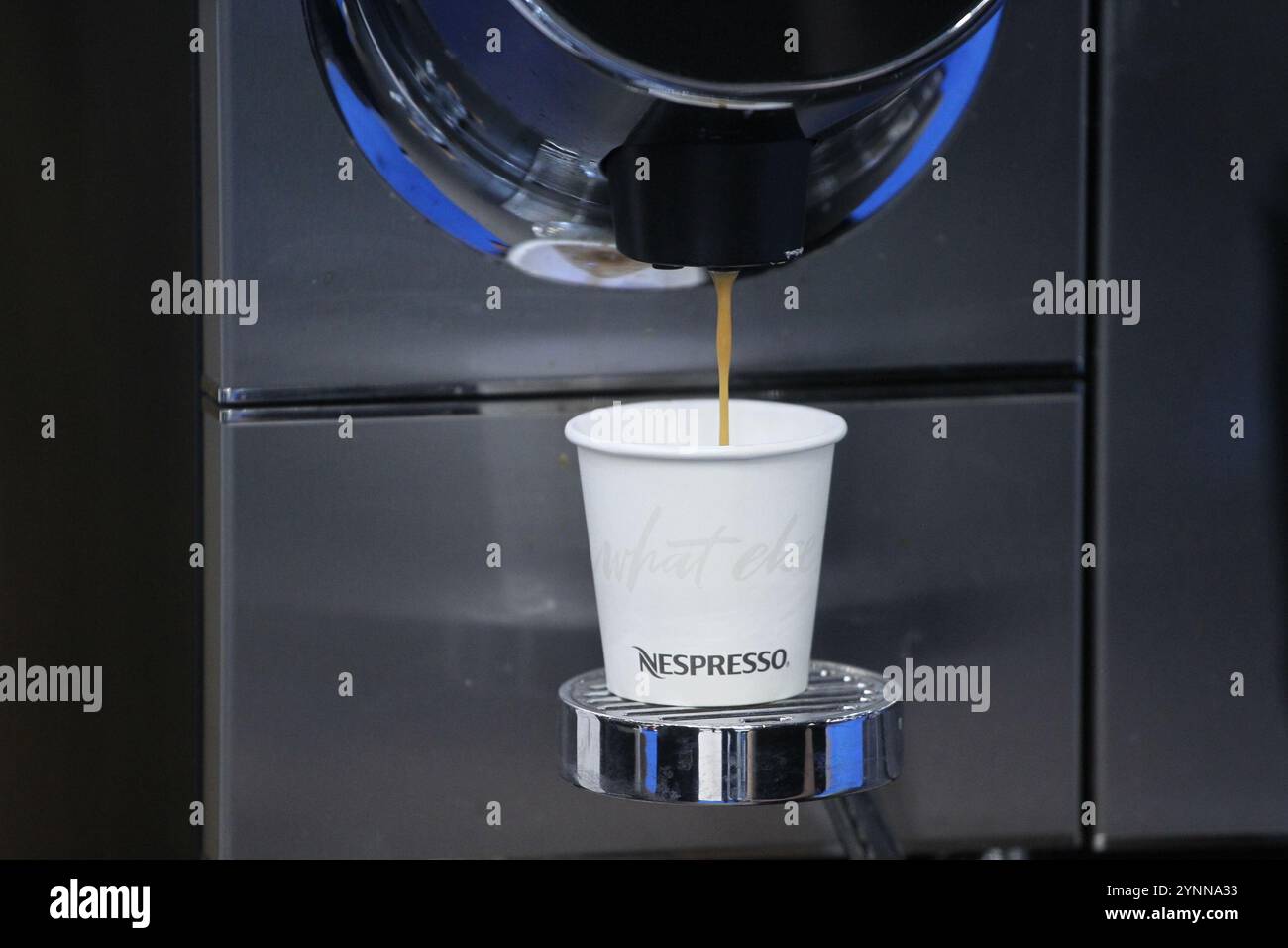 Fresh espresso dripping into a Nespresso-branded paper cup Stock Photo ...