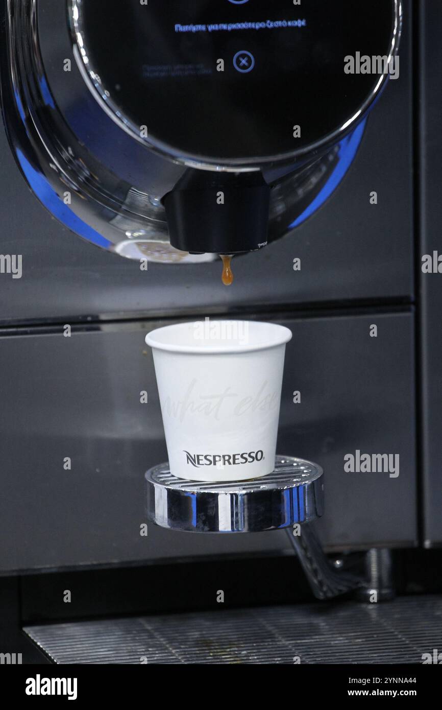 Fresh espresso dripping into a Nespresso-branded paper cup Stock Photo ...