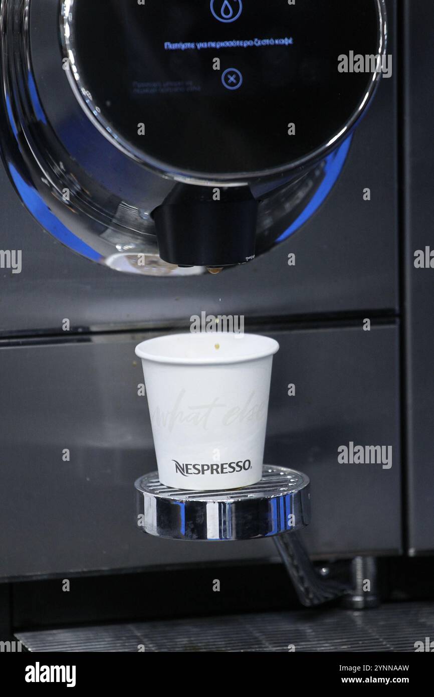 Fresh espresso dripping into a Nespresso-branded paper cup Stock Photo ...
