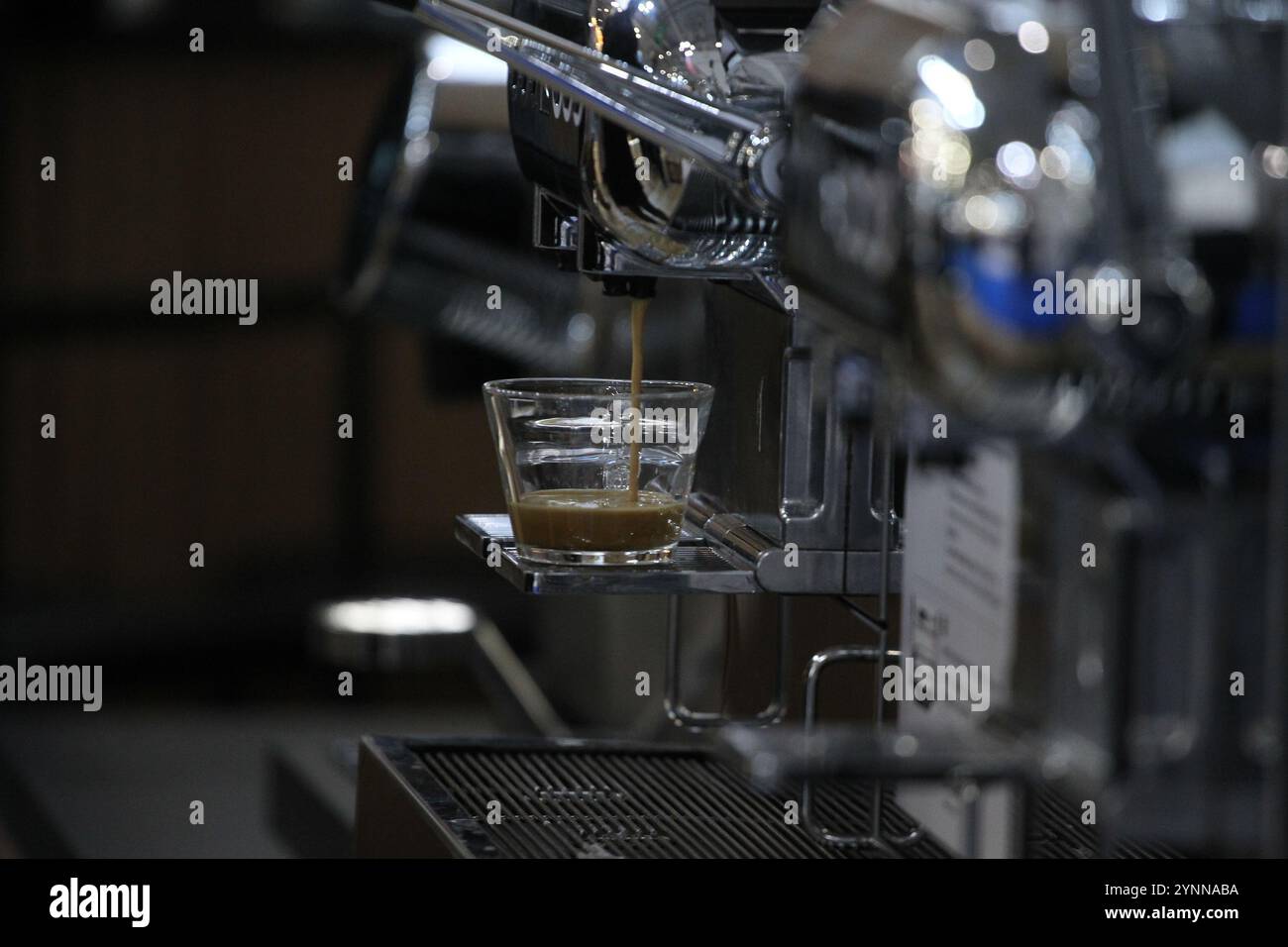 Fresh espresso dripping into a Nespresso-branded paper cup Stock Photo ...