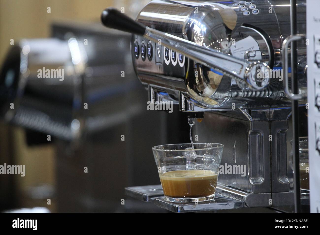 Fresh espresso dripping into a Nespresso-branded paper cup Stock Photo ...