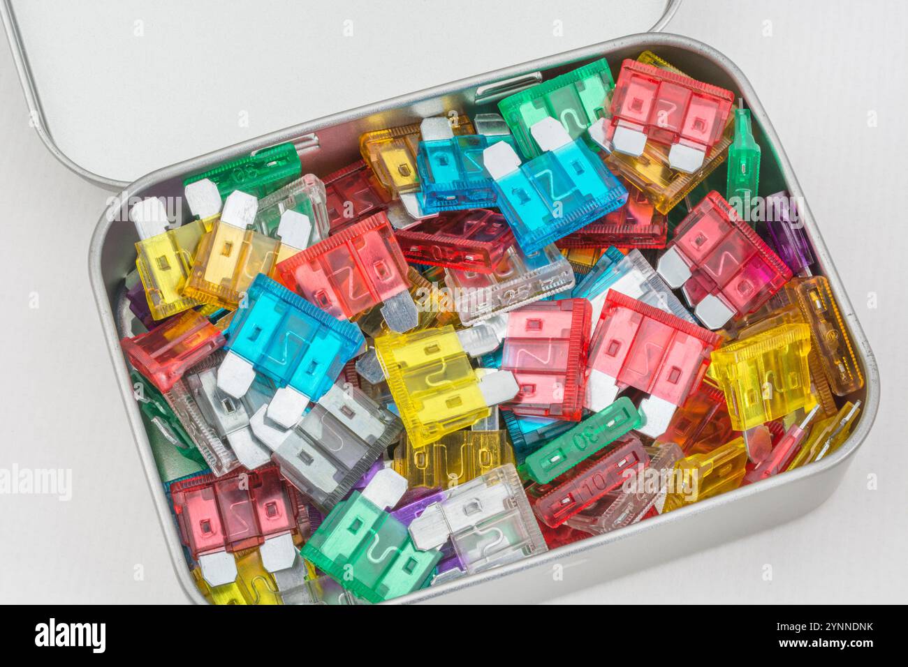 Tin of mixed, disordered, colorful automotive plug-in car fuses in ...