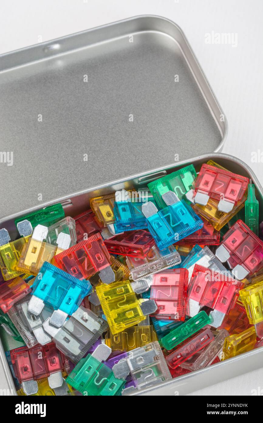 Tin of mixed, disordered, colorful automotive plug-in car fuses in ...