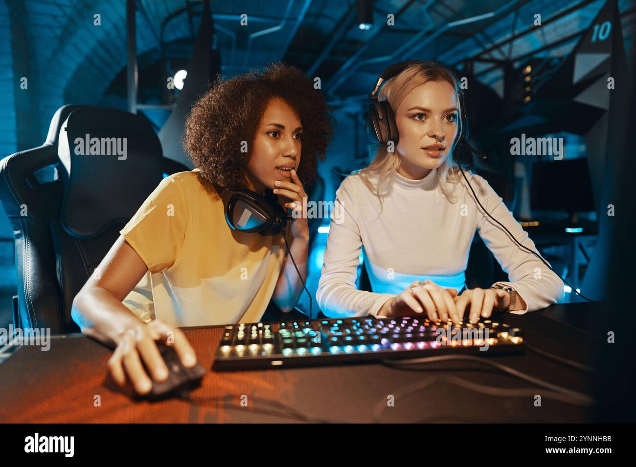 Two young women gaming together in a modern esports cafe at night Stock ...