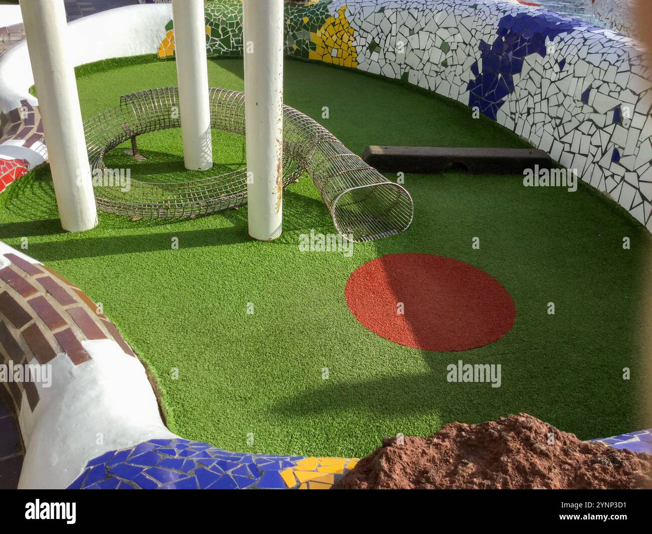 A vibrant playground features artificial turf with a circular design ...