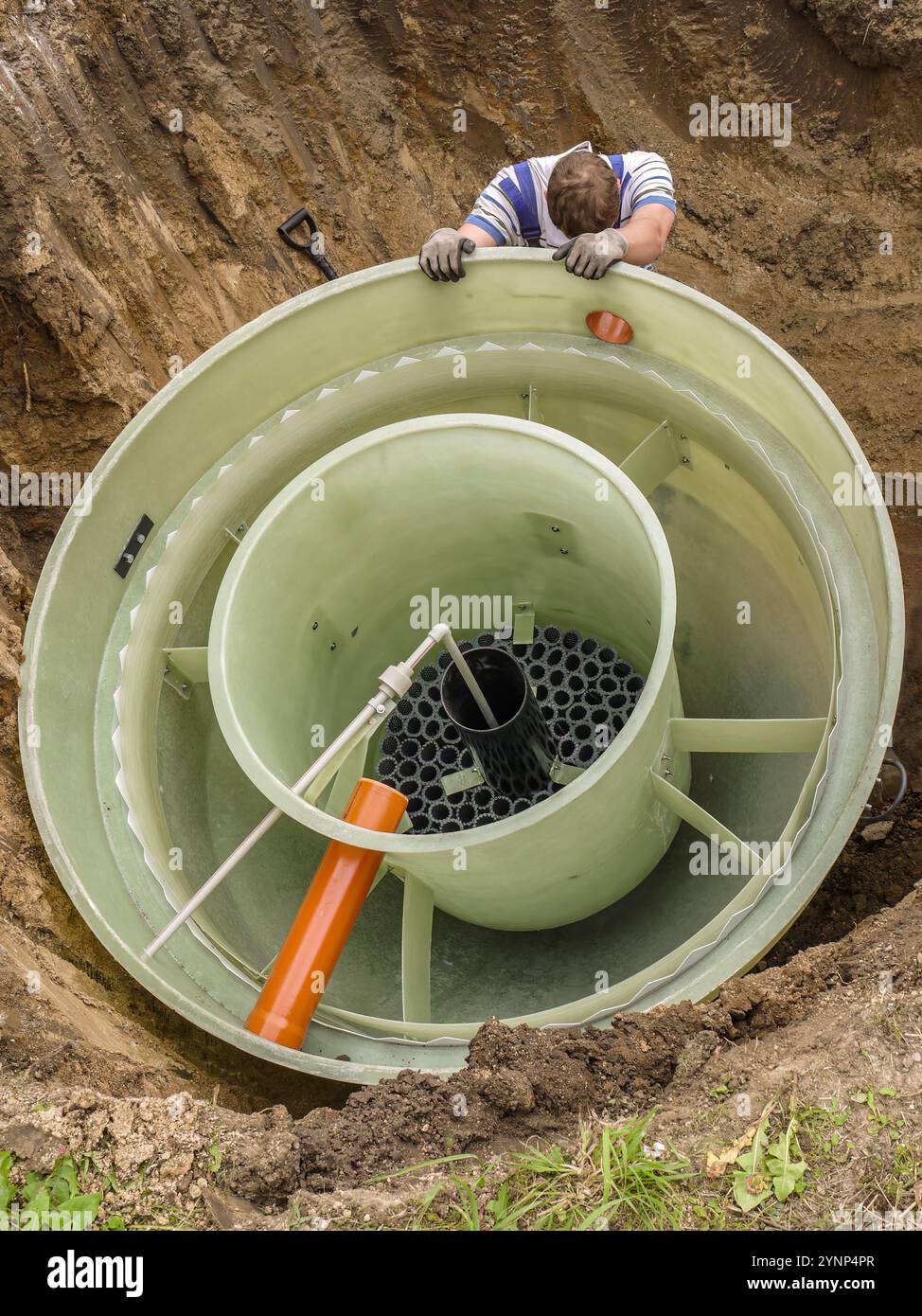 A construction worker assisting at installation of domestic biological ...