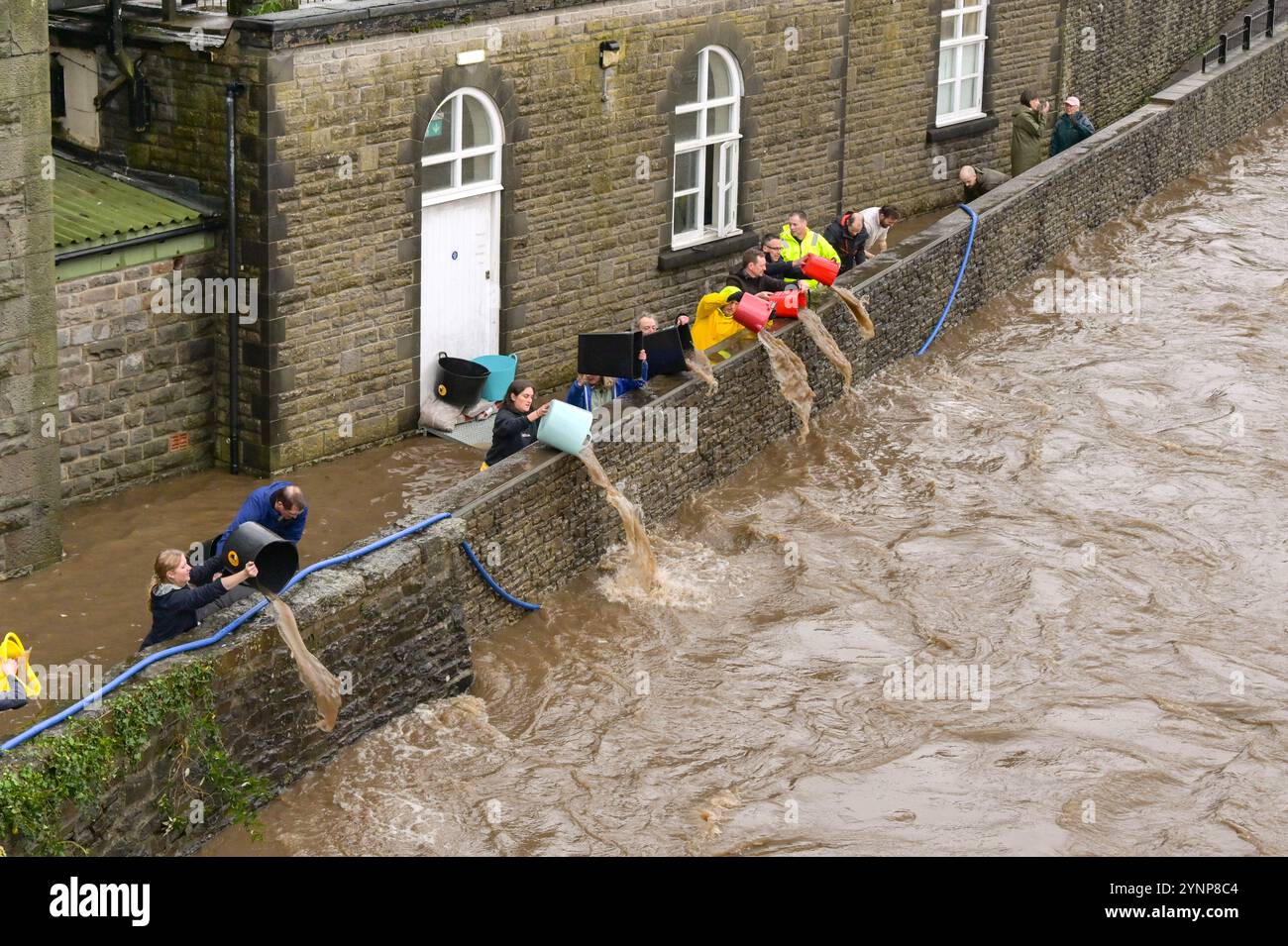 Pontypridd, Wales, UK - 24 November 2024: Volunteers using buckets and ...