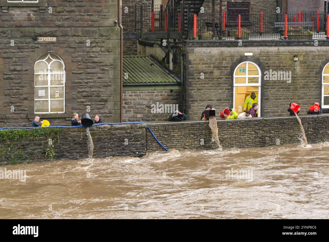 Pontypridd, Wales, UK - 24 November 2024: Volunteers using buckets and ...
