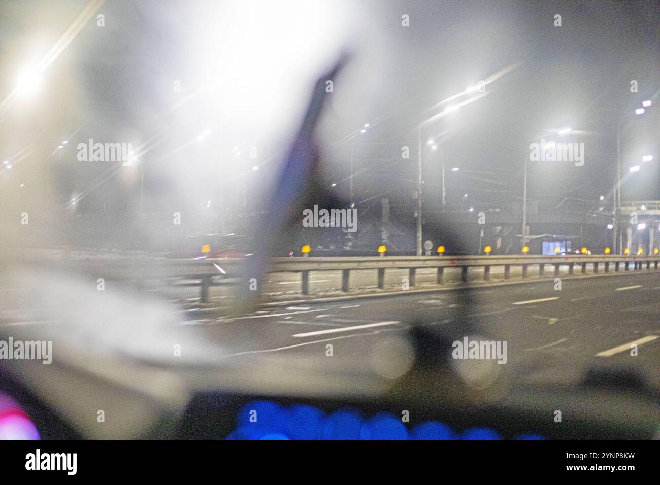 fogged car windshield in evening lights while driving. Poor visibility ...