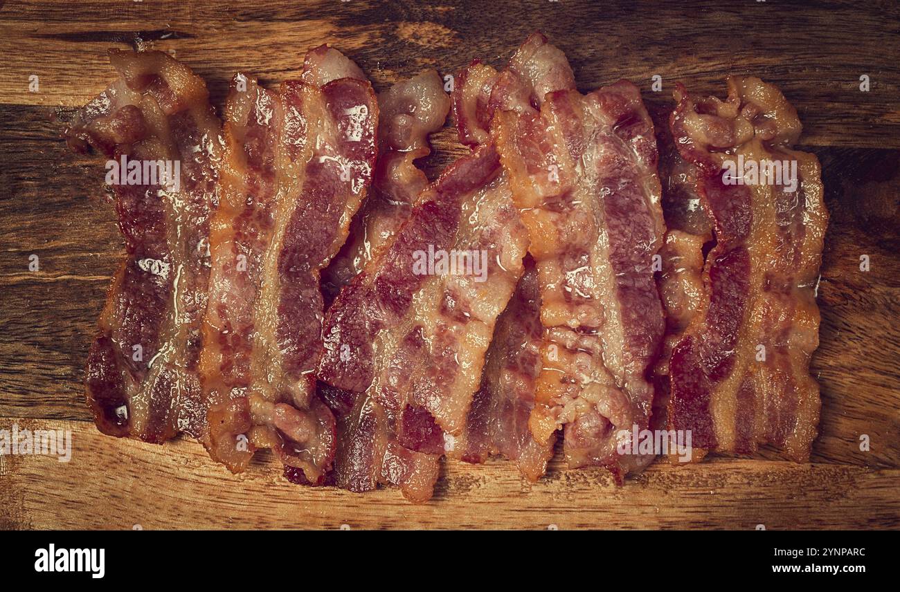 Fried bacon on a cutting board, top view, close-up, homemade, breakfast ...