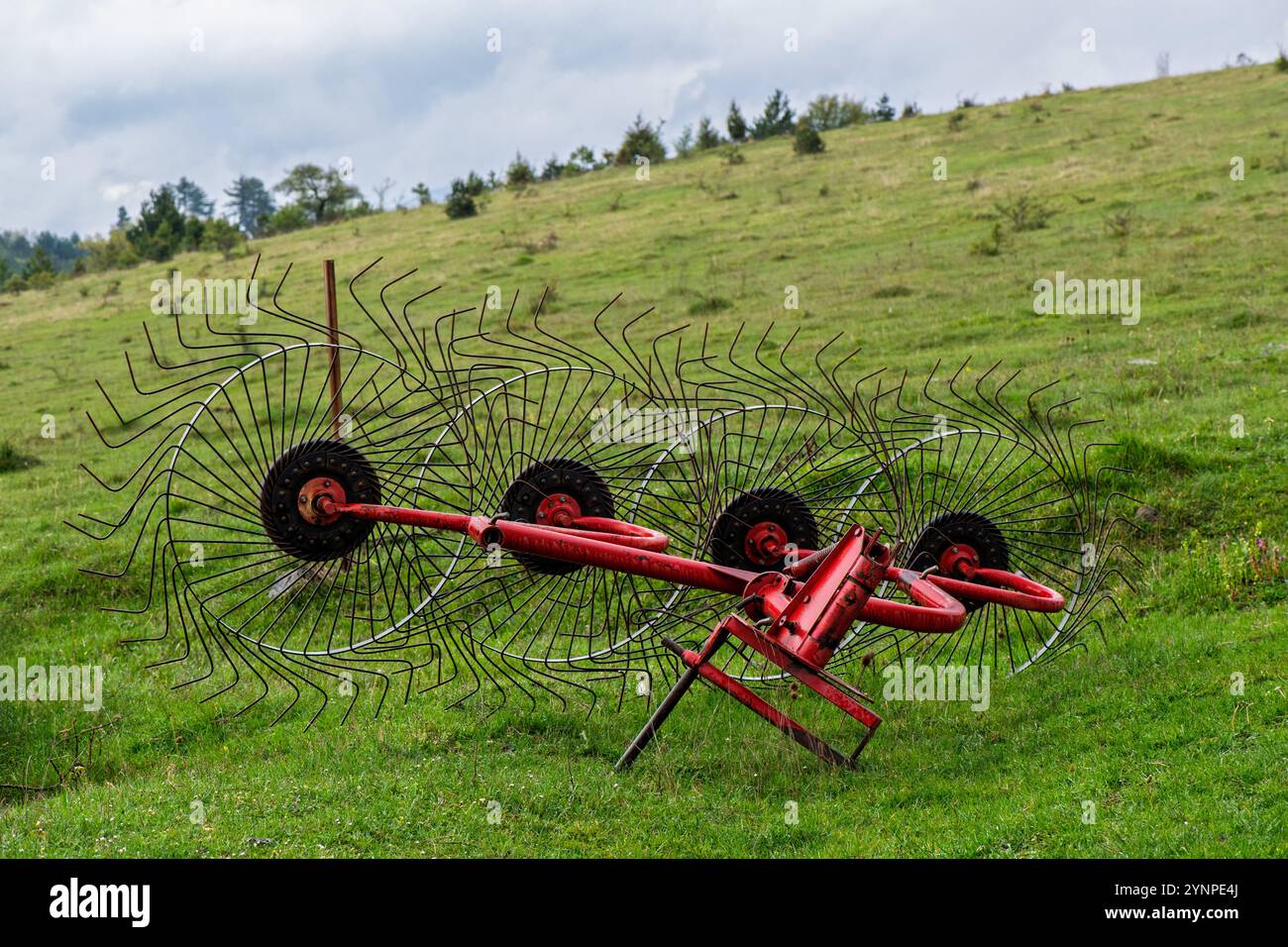 Rustic Hay Rake on Green Hillside Stock Photo - Alamy