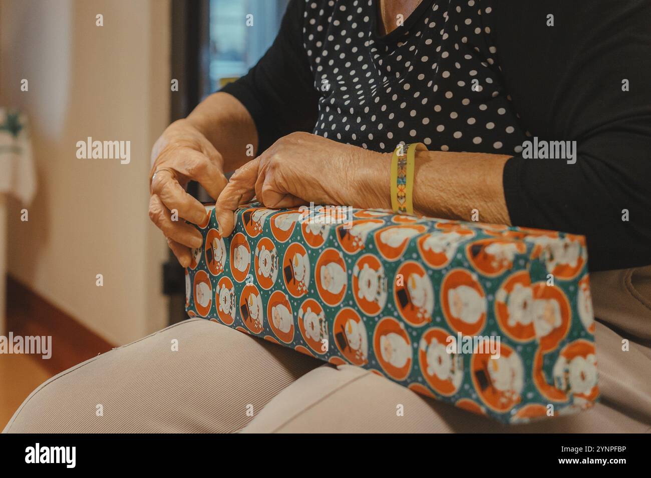 Unwrapping gifts from under the Christmas tree. Gift wrapped in ...