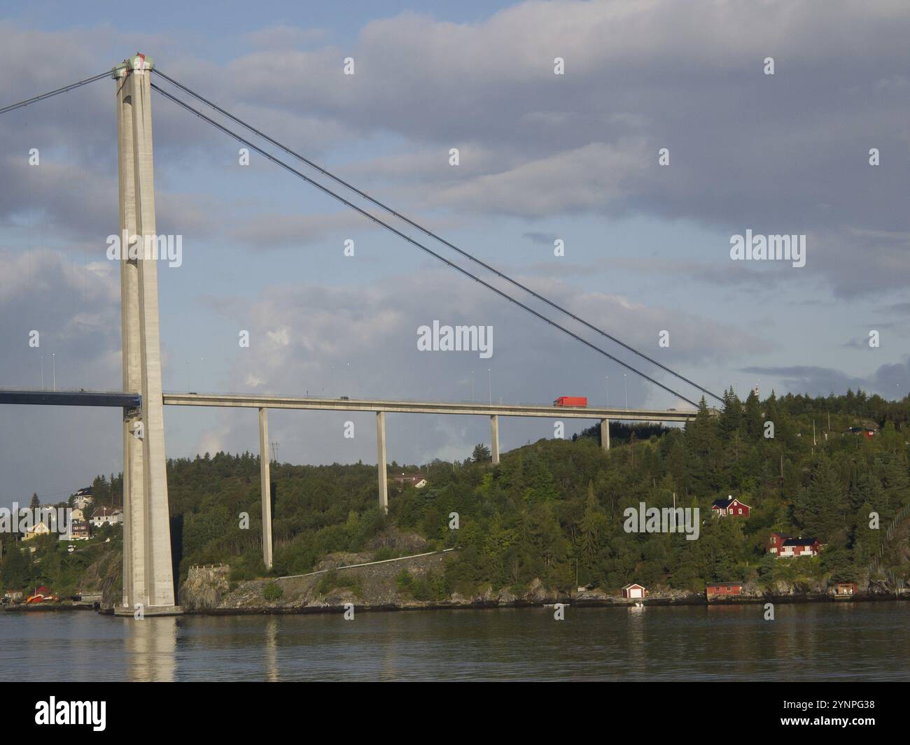 Suspension bridge over a waterway with a lorry, surrounded by forest ...