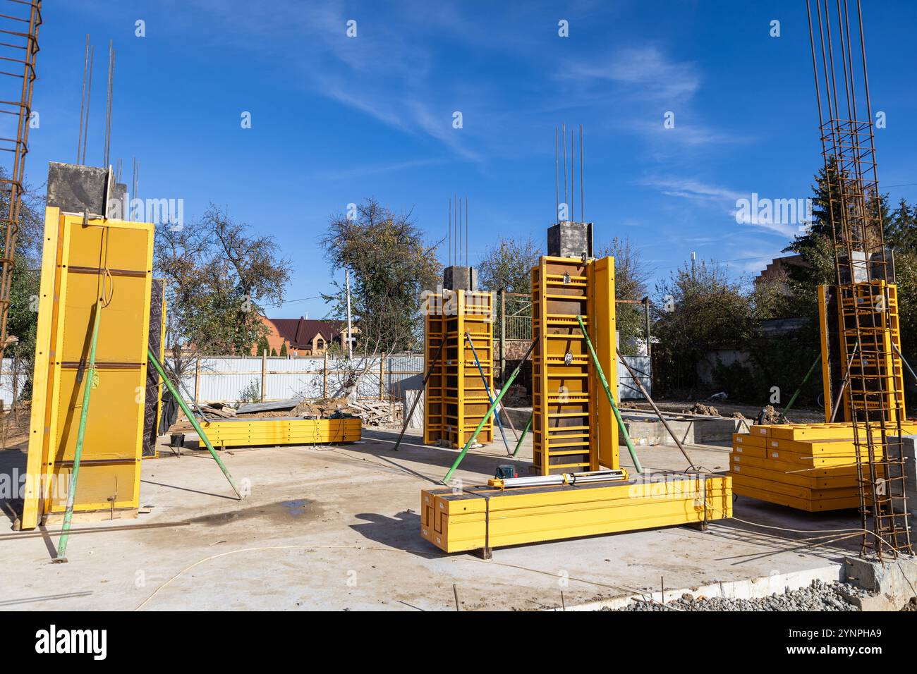 Yellow column formwork and steel rods at construction site, concrete ...