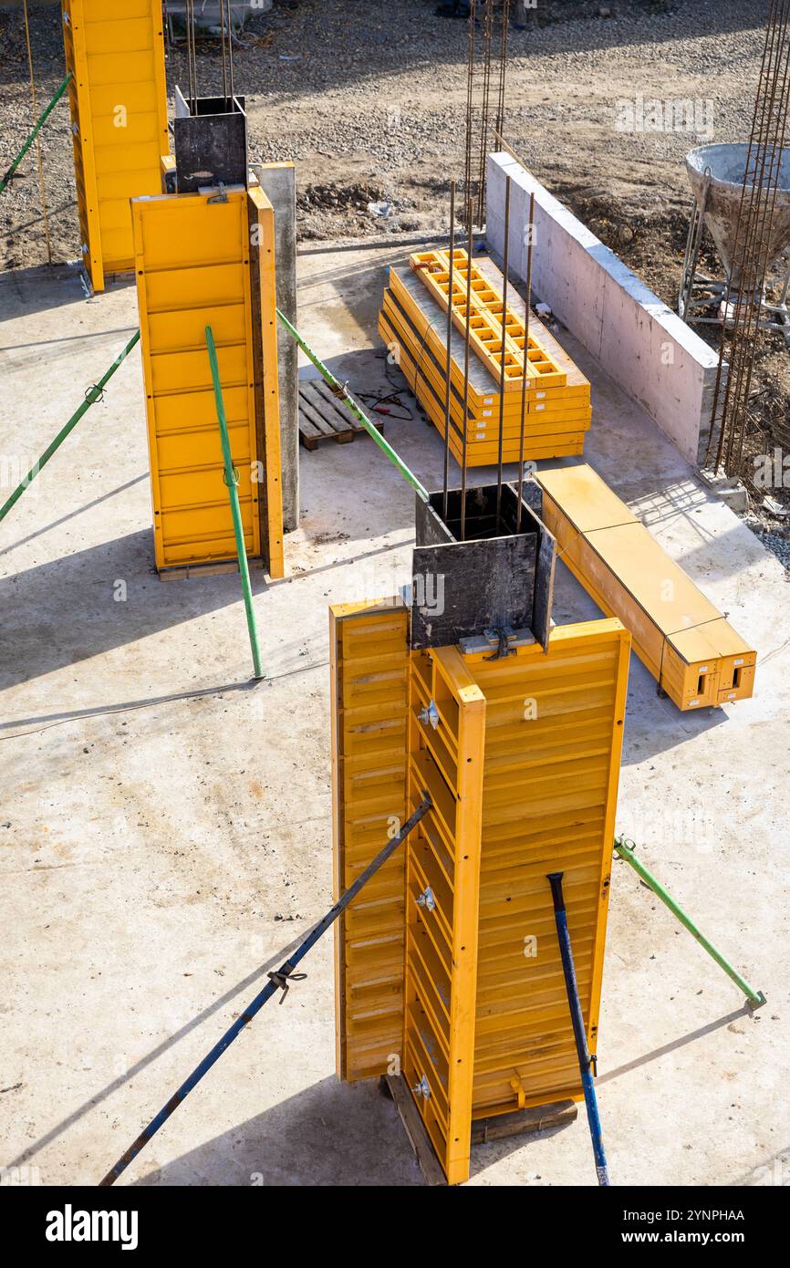 Yellow column formwork and steel rods at construction site, concrete ...