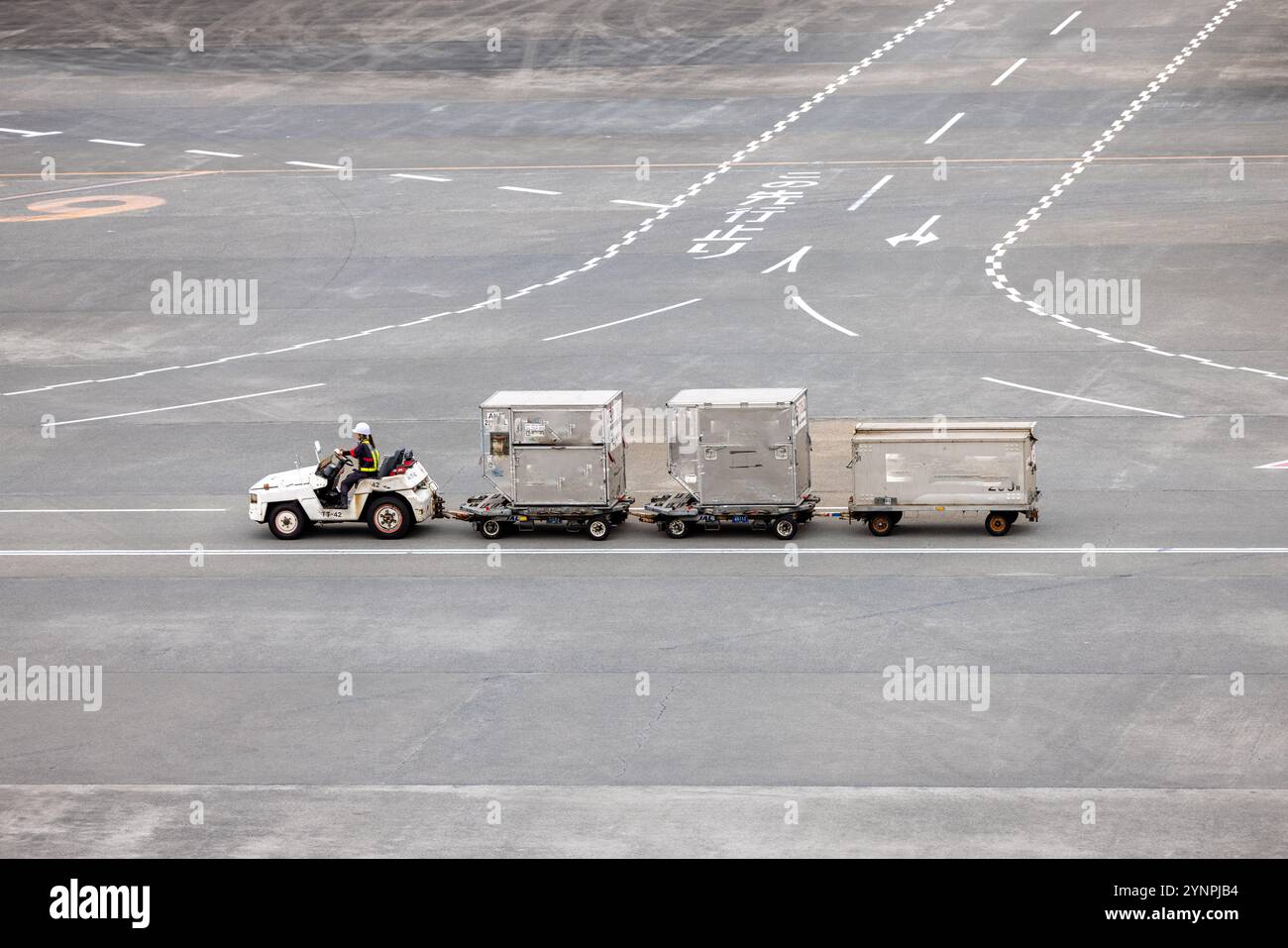 Airport ground vehicle towing cargo containers on the tarmac Stock ...