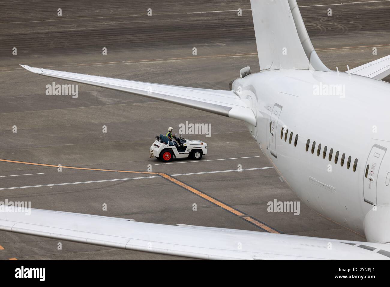 Airport ground vehicle driving near airplane tail and wing on the ...