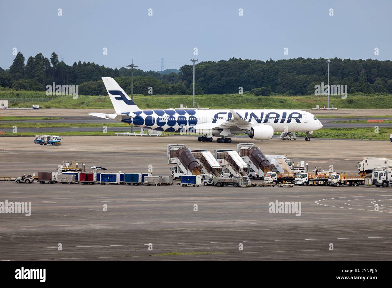 Finnair airplane on the tarmac with ground service equipment at the ...