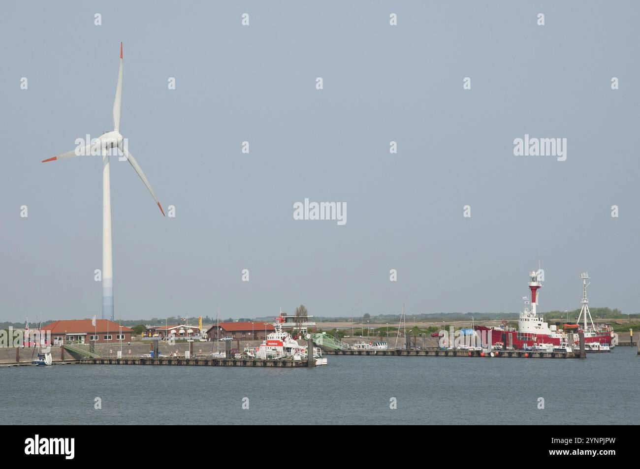 Harbour view with a wind turbine and several ships, modern and ...