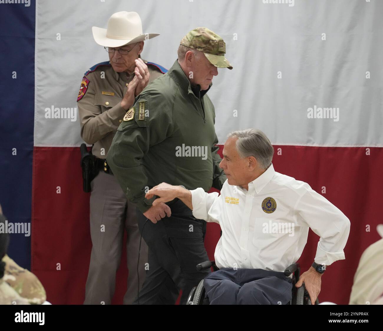 Eagle Pass Texas USA, Nov. 26 2024: Texas Gov. Greg Abbott (seated ...