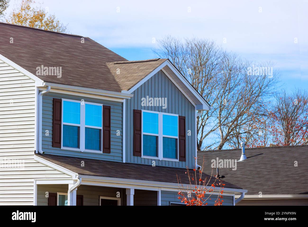 Beautiful two story house showcases large windows framed by wooden shutters suburban setting ...