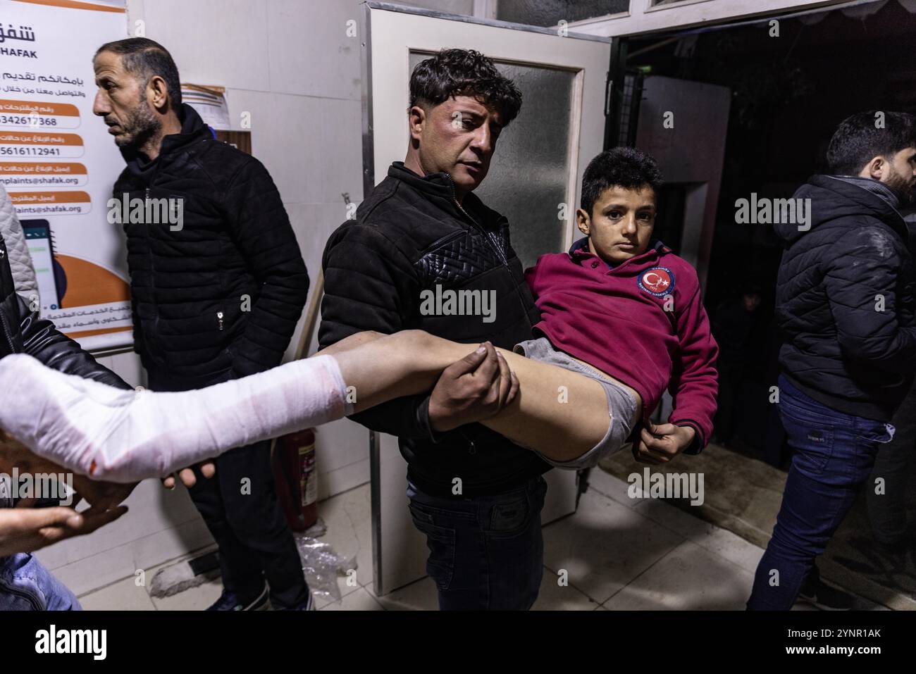 Ariha, Syria. 26th Nov, 2024. An injured boy is treated after the ...