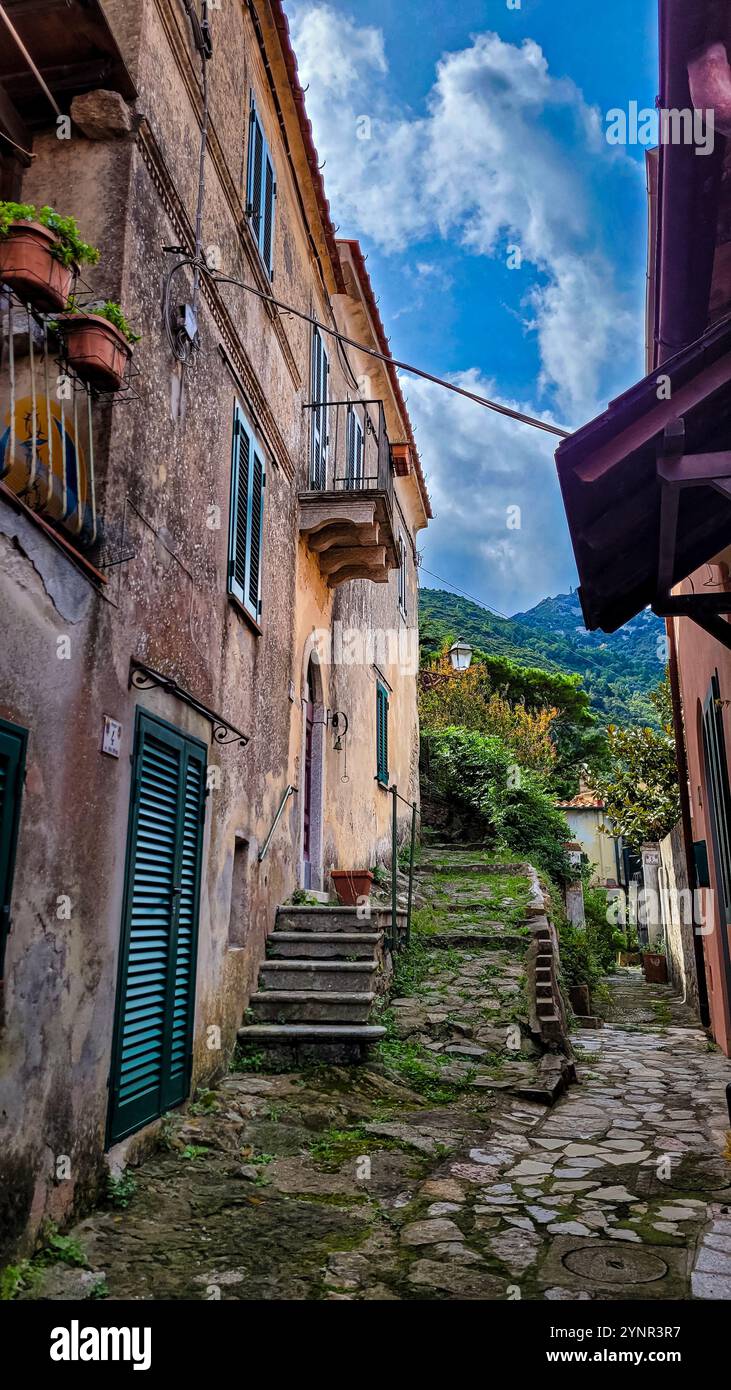 The narrow beautiful street of the Italian town with peeling houses and ...