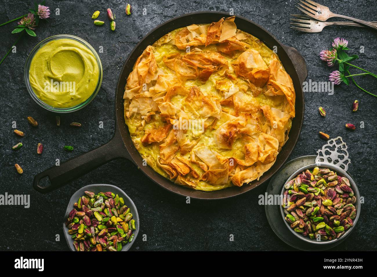 Overhead shot of cast iron skillet with ruffled phyllo pie with ...