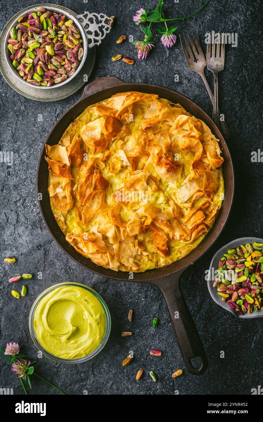 Overhead shot of cast iron skillet with ruffled phyllo pie with ...