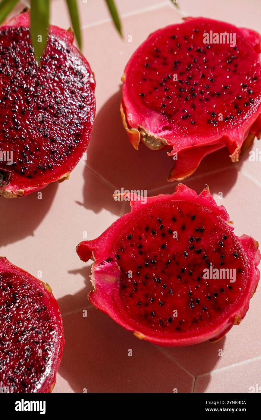 dragon fruit, also known as pitaya, cut open pink magenta-colored flesh ...