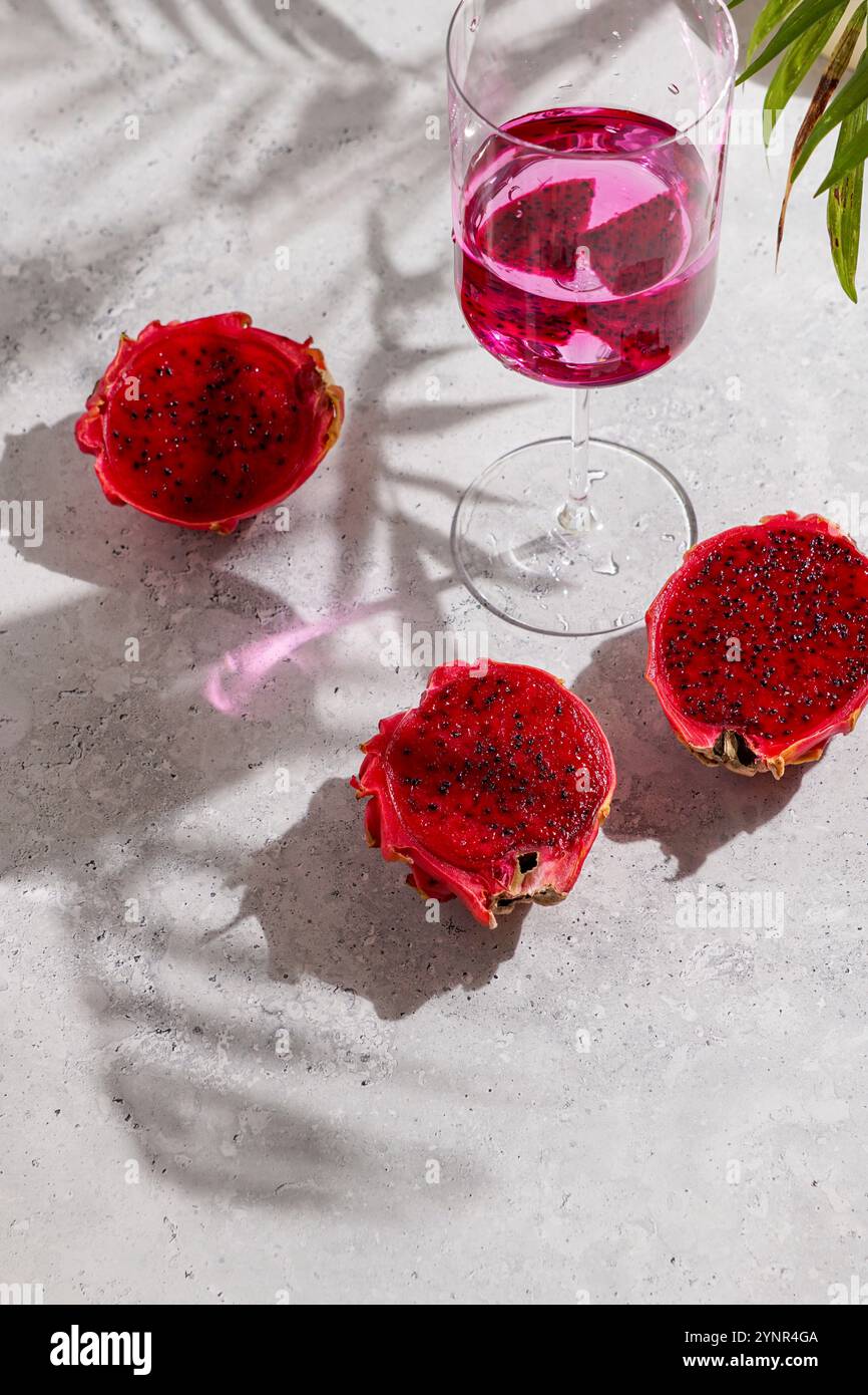 glass with cocktail, dragon fruit, also known as pitaya, cut open pink ...