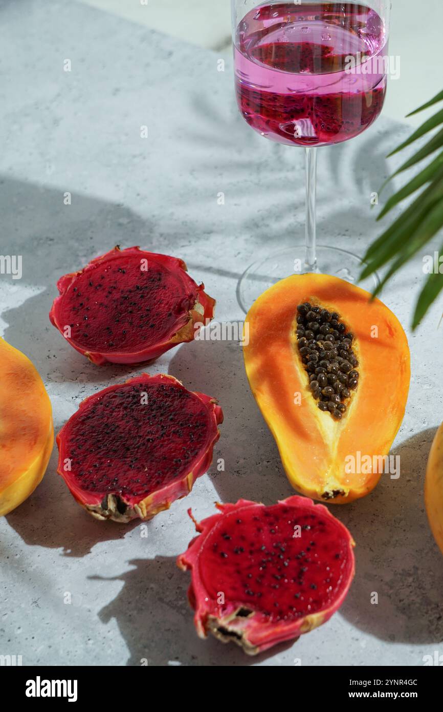 glass with cocktail, dragon fruit, also known as pitaya, cut open pink ...