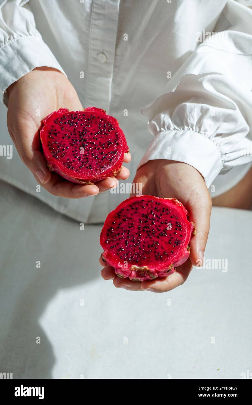 dragon fruit, also known as pitaya, cut open pink magenta-colored flesh ...