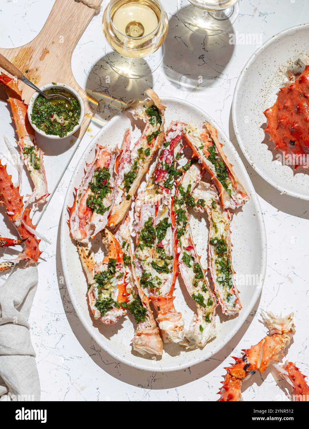 Delicious crab legs garnished with fresh herbs and garlic serve as the ...