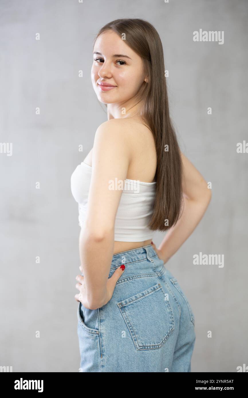 Girl in white strapless top is half-turned to camera Stock Photo - Alamy