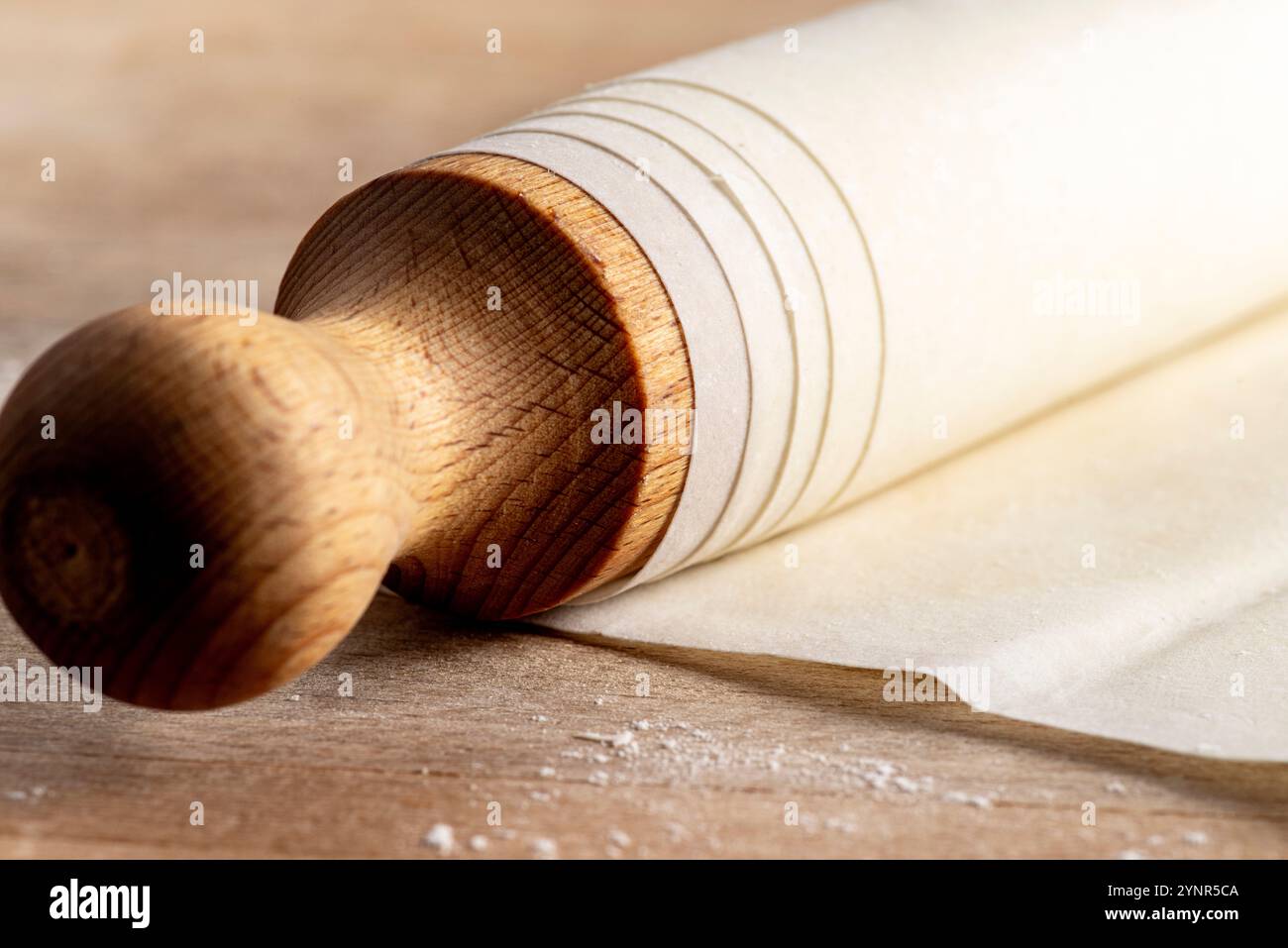 Positioned diagonally on a wooden cutting board, the rolling pin is ...
