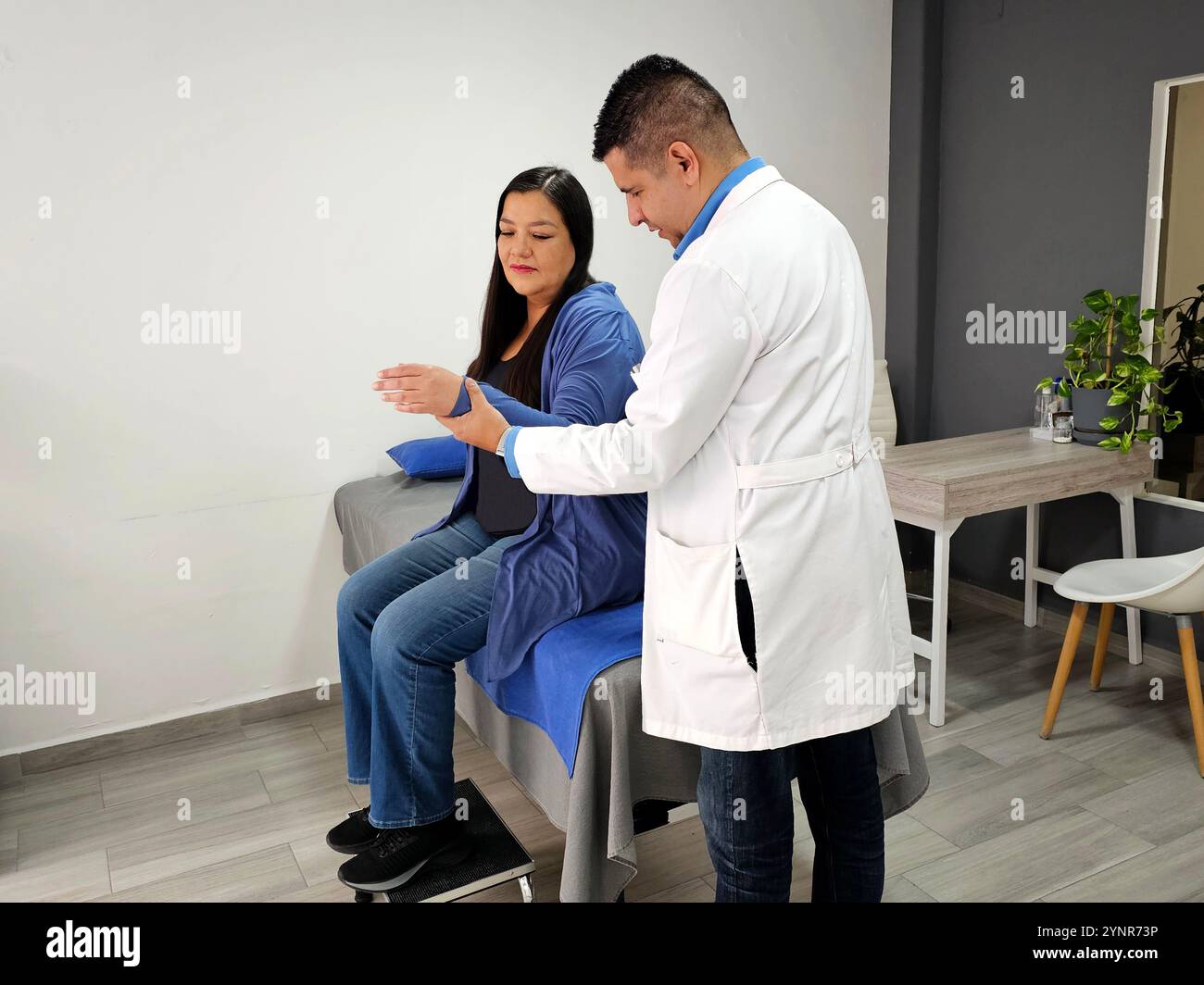 Dark-skinned man doctor medical specialist checks Latin woman patient ...